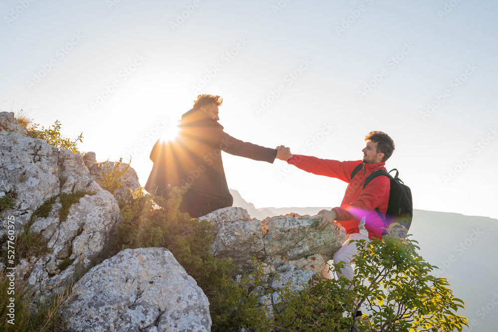 Hiking team helping each other friend giving a helping hand while ...