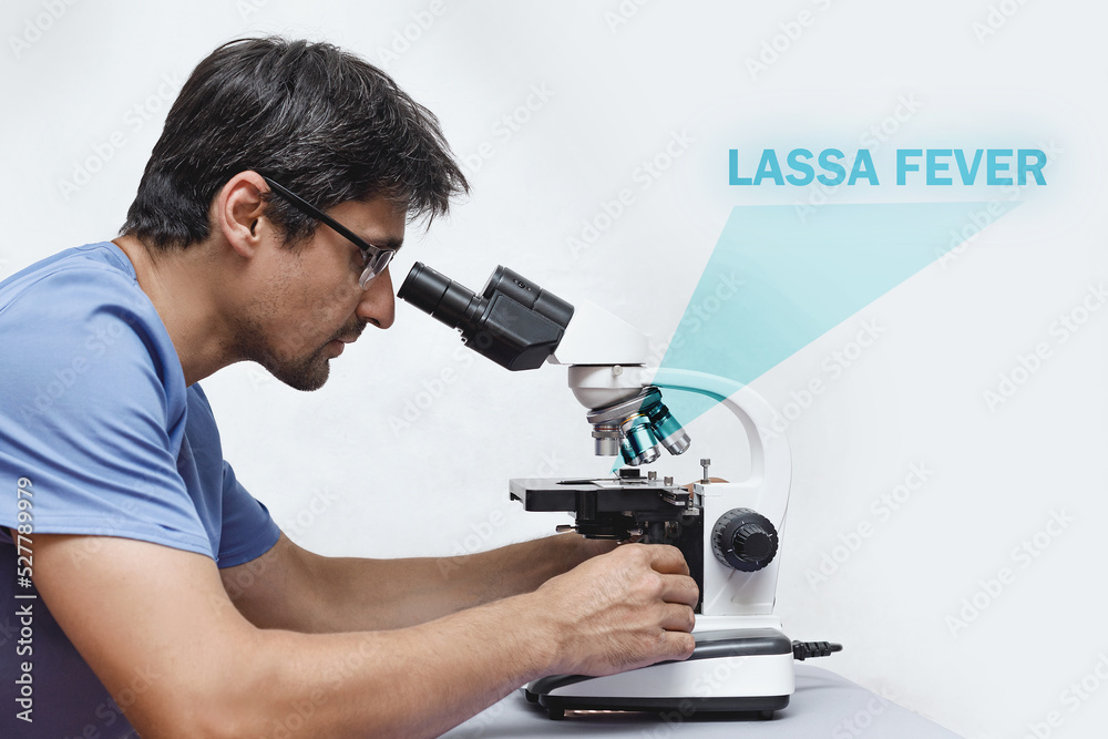 A brunette histologist doctor in a blue medical uniform looks in a ...