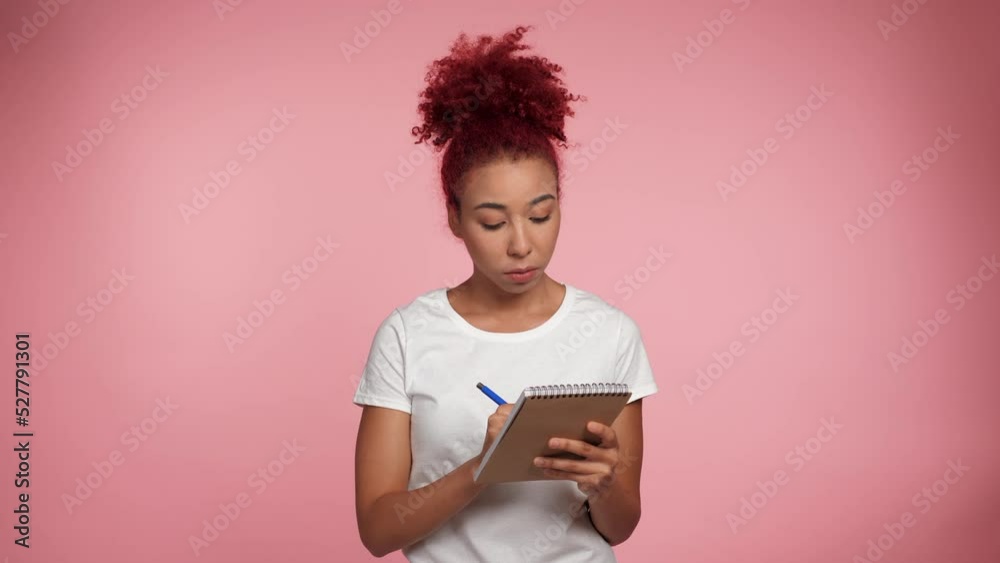 Thoughtful smiling creative African American woman with red hair taking ...