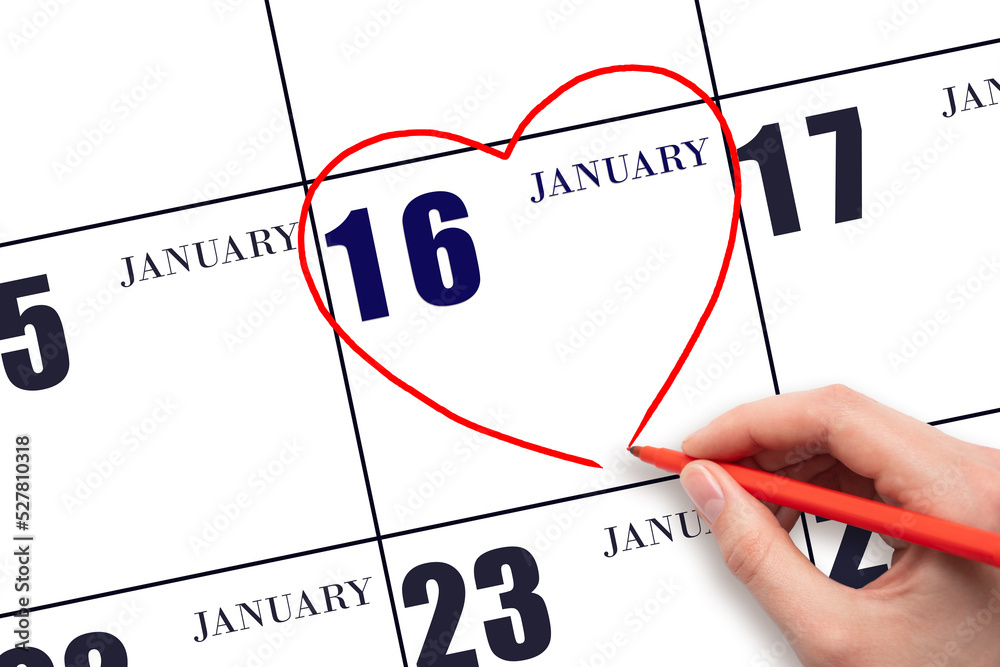 A woman's hand drawing a red heart shape on the calendar date of 16 ...