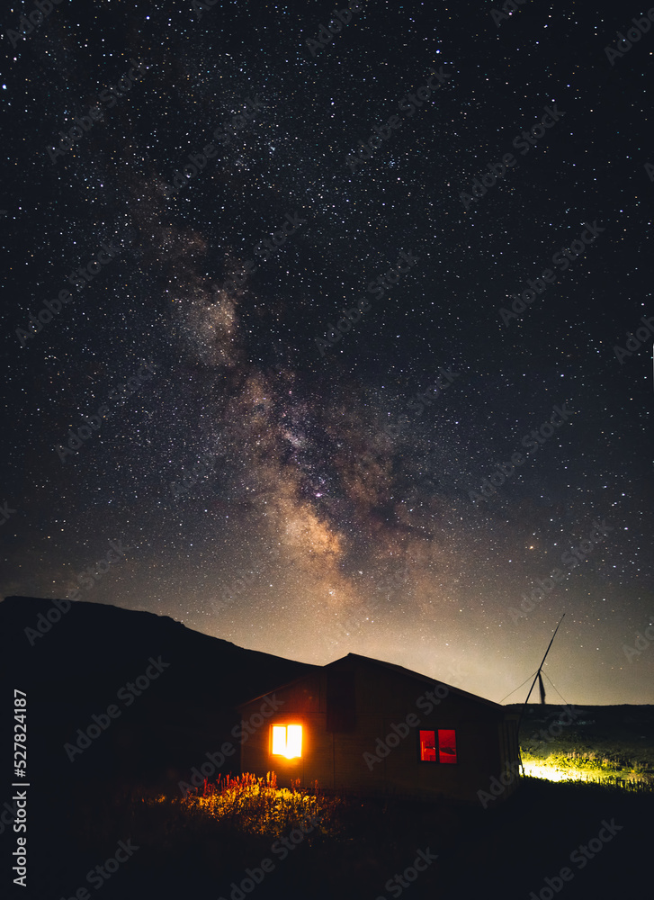 Nightscene of illuminated wooden house hut in mountains isolated with ...