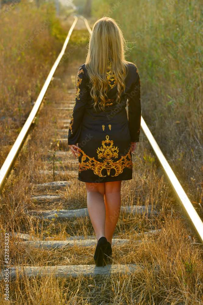 A sad girl, after parting with her beloved, goes along the rails to ...