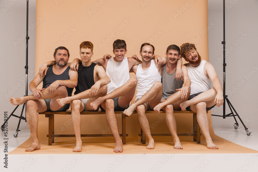 Six young men of different ages having photo shoot at studio. Feeling ...