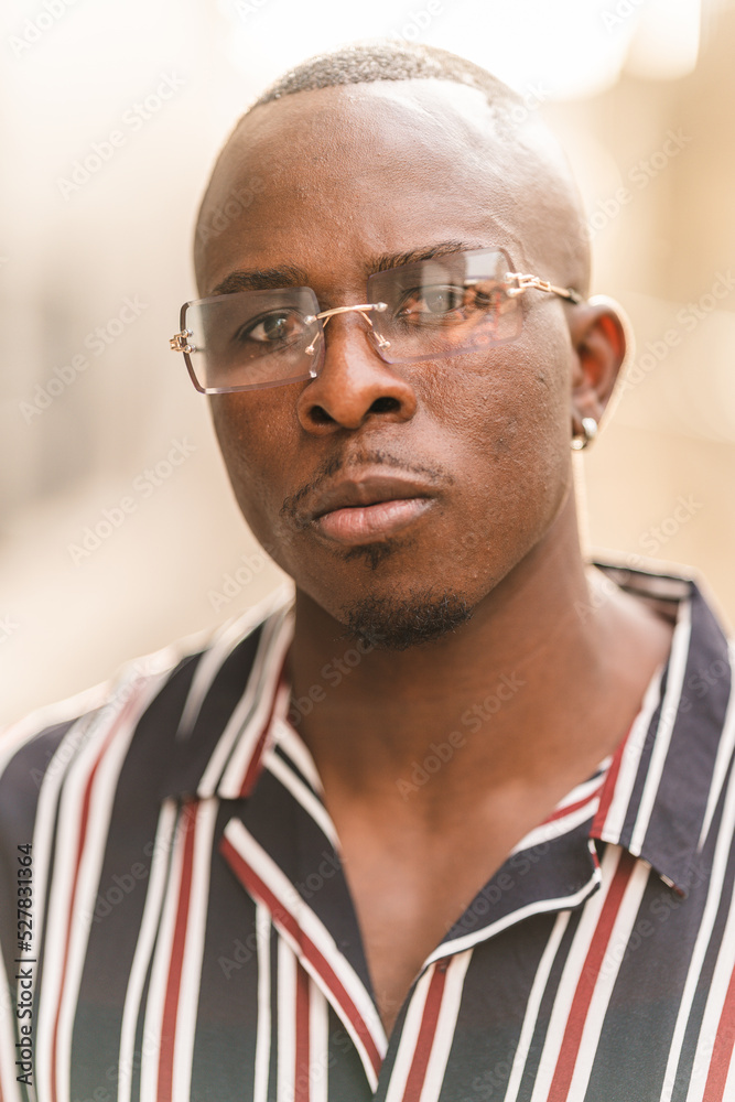Chico negro joven rapado con camisa de rayas verticales posando en la ...