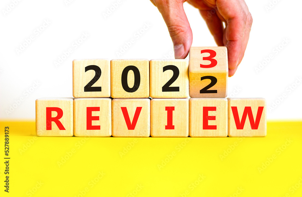 2023 review new year symbol. Businessman turns a wooden cube and ...