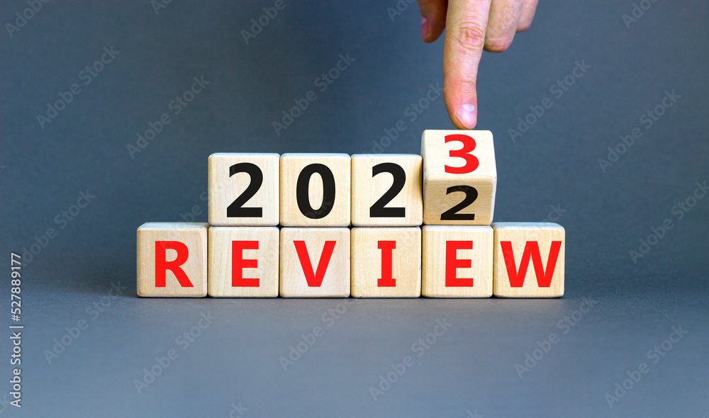 Foto de 2023 review new year symbol. Businessman turns a wooden cube ...