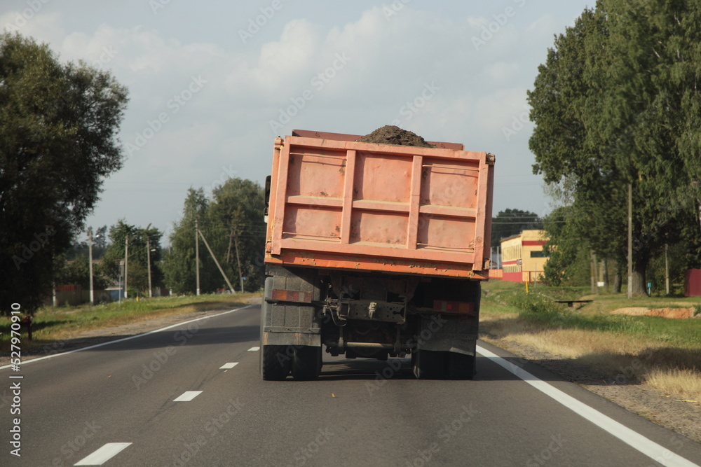 Heavy overloaded curvy dumper truck drive with bulk cargo on a European ...