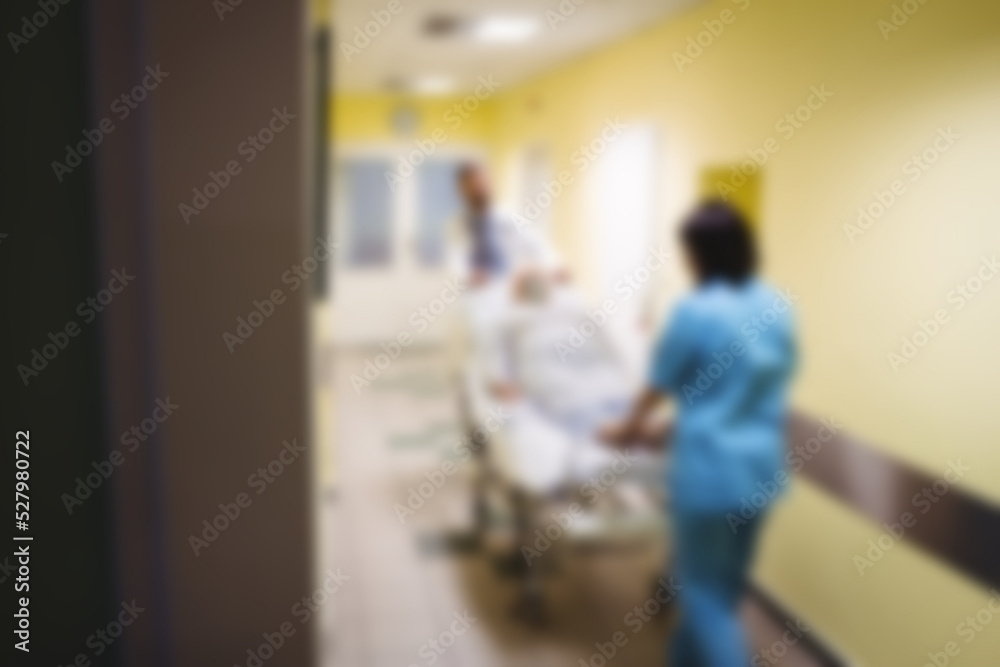 Doctor pushing patient in hospital bed through corridor Stock Photo ...