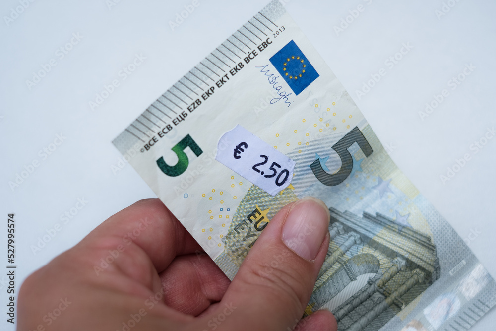 Five euro banknote with 2 euro 5 cent price tag. Selective focus on ...