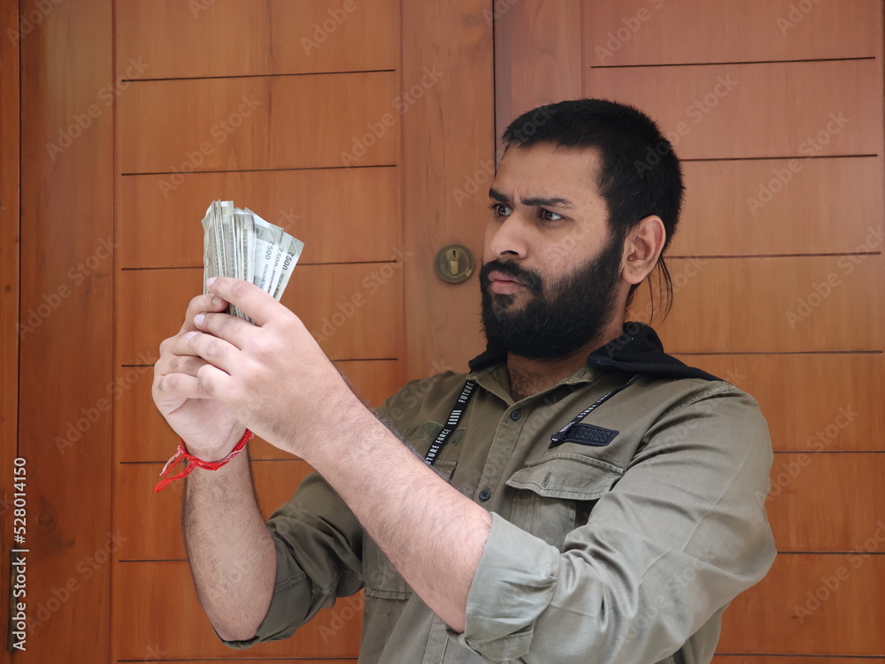 Foto de Angry man finding Fake Indian rupees. Concept shot of receiving ...