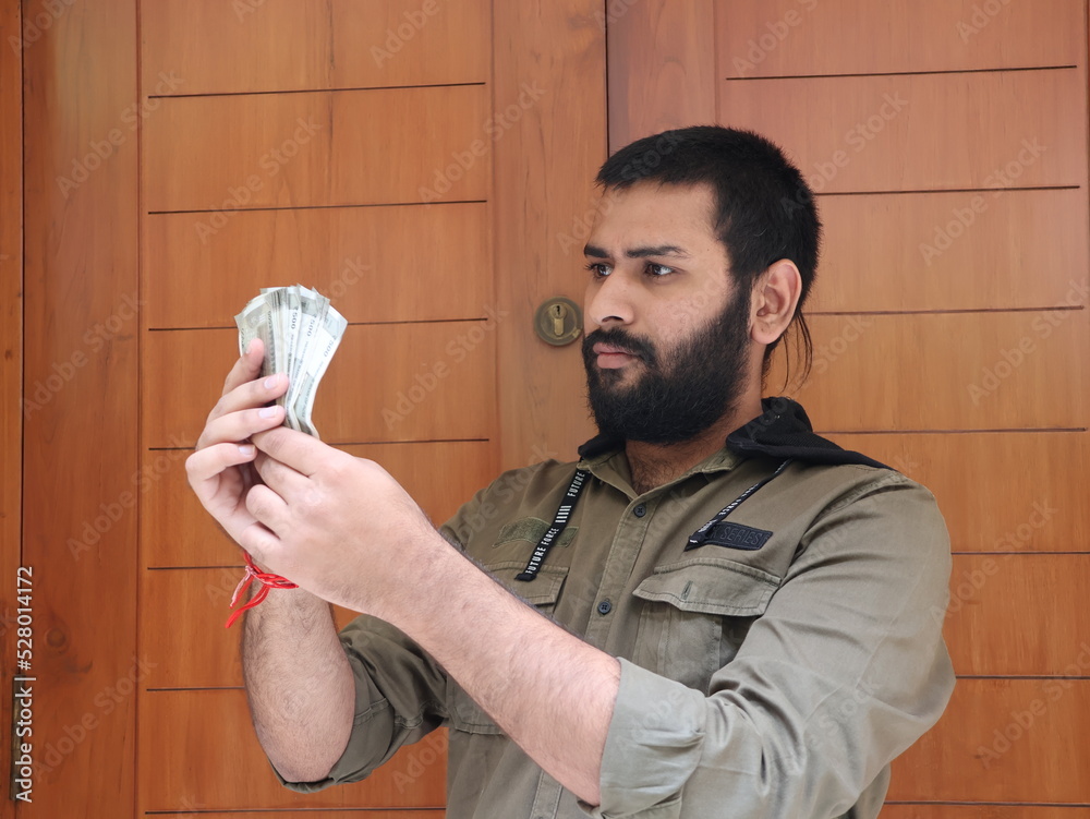 Foto de Angry man finding Fake Indian rupees. Concept shot of receiving ...
