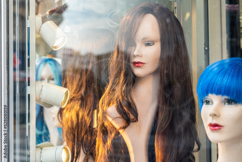 Female mannequin heads with wigs, behind a wig shop window Stock Photo ...