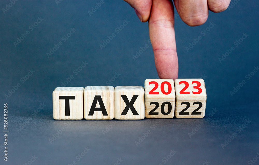 2023 tax new year symbol. Businessman turns a wooden cube and changes ...