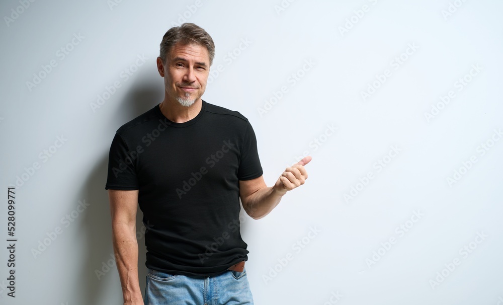 Portrait of happy casual older man smiling, Showing, pointing at ...