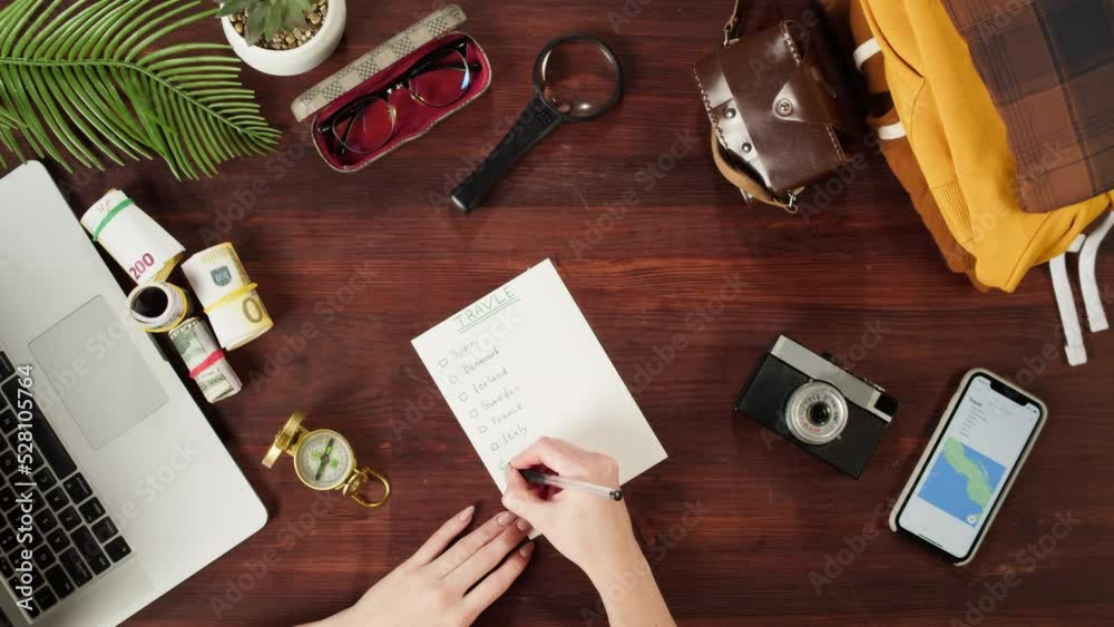 Writing list for travelling top view. Planning tour abroad. Man using ...