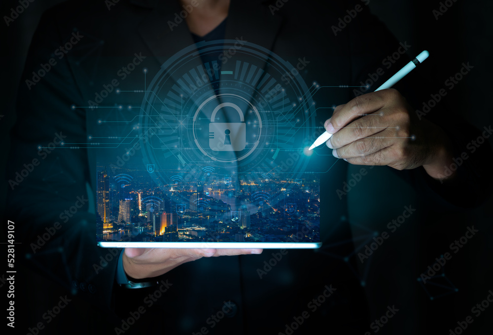 Computer security concept. Businessman holding tablet with cityscape ...