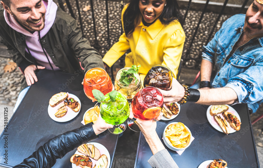 High-angle shot of multiracial friends toasting at cocktail bar with ...