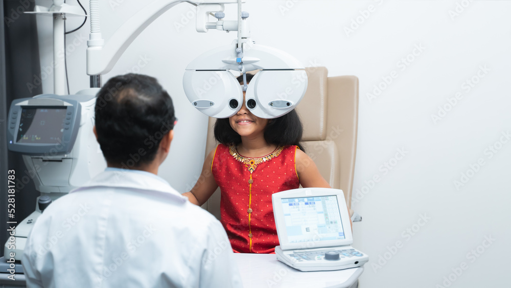 Happy Indian child girl doing subjective refraction with phoropter ...