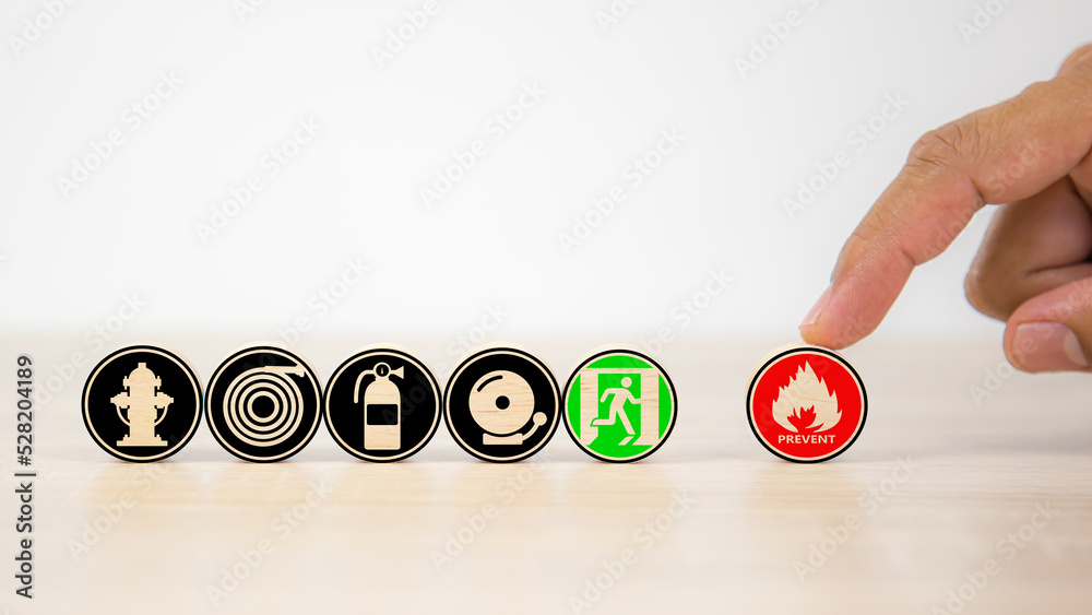 Hand choose wooden toy stack with fire prevent icon on door exit sing ...