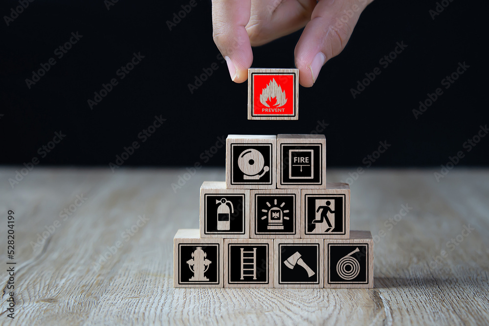 Hand choose cube wooden toy stack pyramid with fire prevent icon on ...
