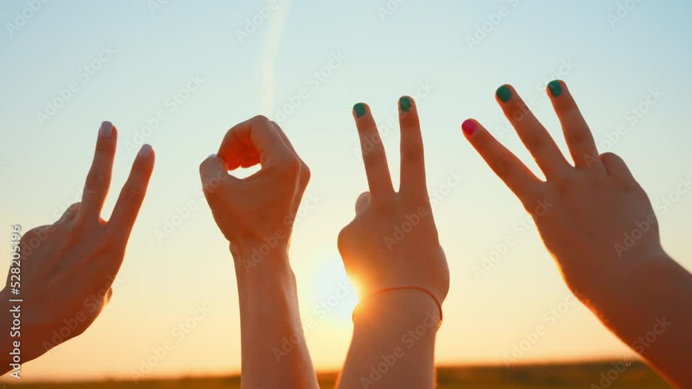 Signs symbols with four human hands against blue sky. Two,three fingers ...