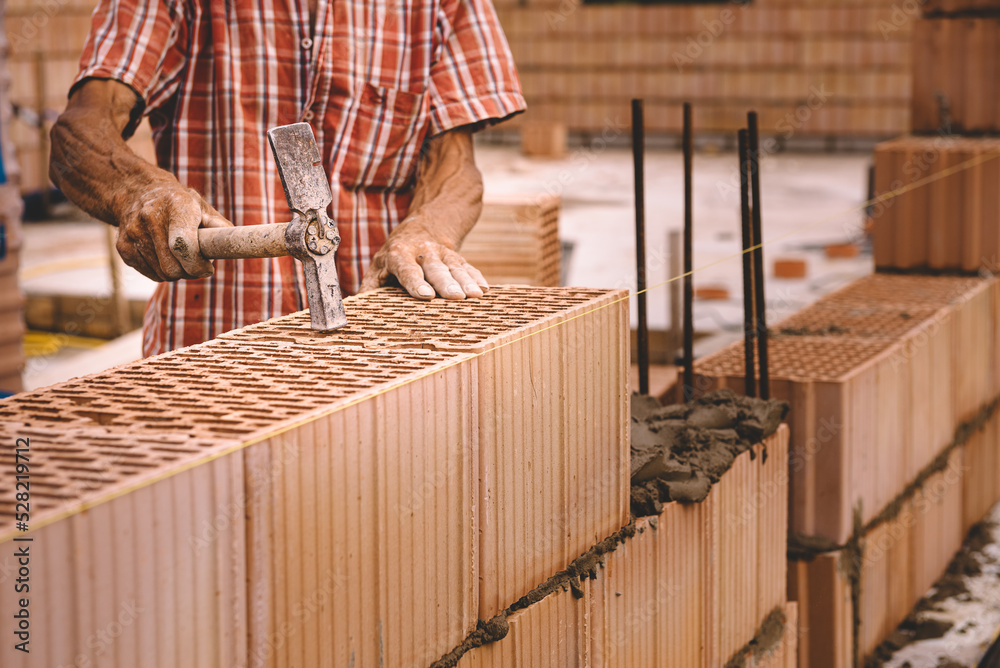 Professional construction worker laying bricks and mortar - building ...