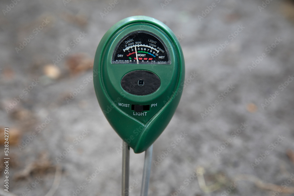 Soil measurements with a digital device. Green plants measure pH and ...