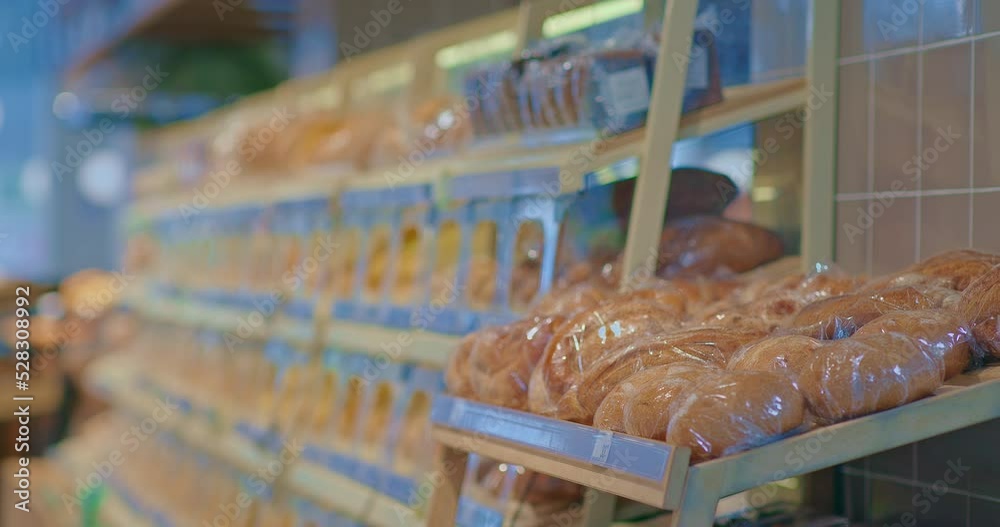 Baguettes and loaves of bread lie in a row on the supermarket windows ...