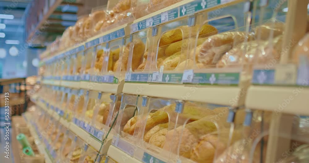 Supermarket, bread products are on display, products in a row. Loaves ...