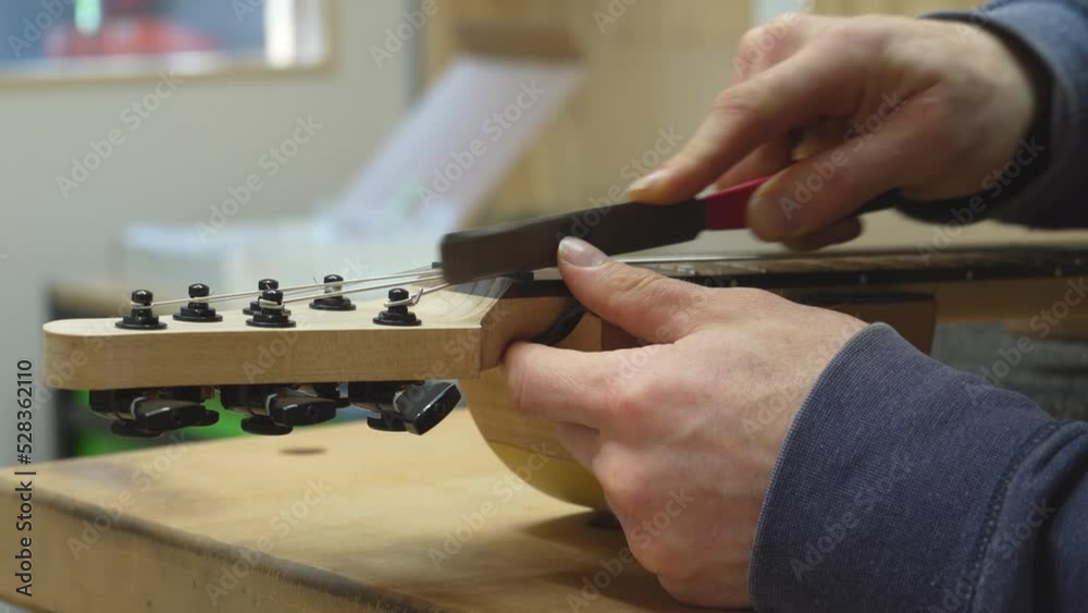 Artisan setting nut height after attaching strings on newly built ...