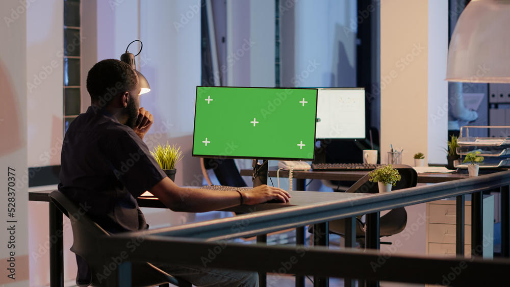 Startup worker analyzing greenscreen on monitor in office with big ...