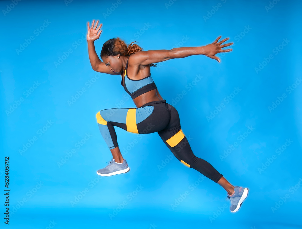 Determined woman running against blue background Stock Photo | Adobe Stock