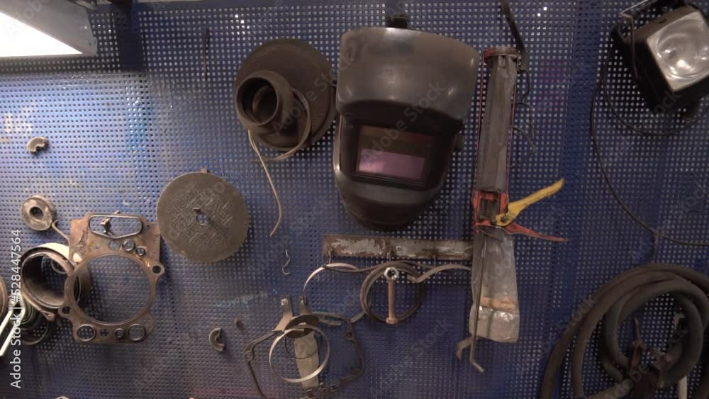 A set of various tools hanging on a vertical perforated panel in a car ...