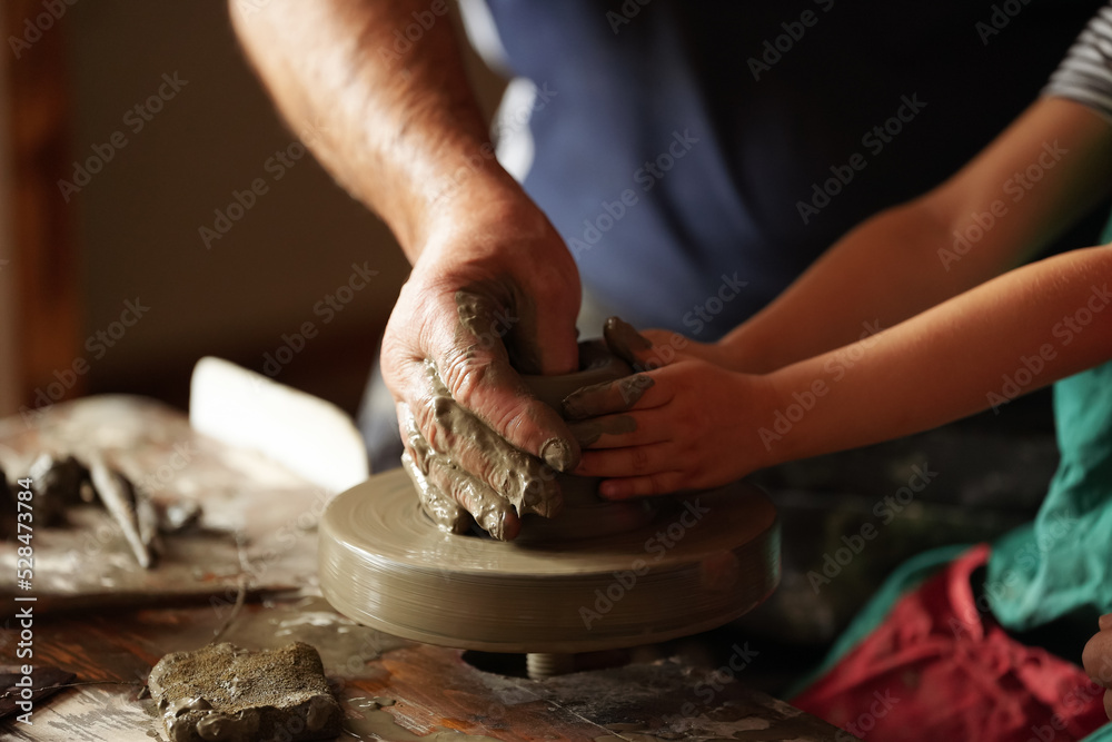 Pottery workshop. A potter teaches a child to make a clay pot. Great ...