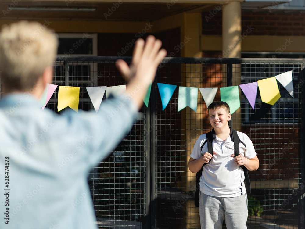 Father saying goodbye to his son before entering at school. Selective ...