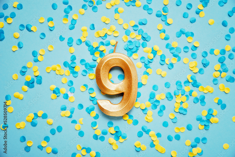 Foto Stock Number 9 nine golden celebration birthday candle on yellow ...