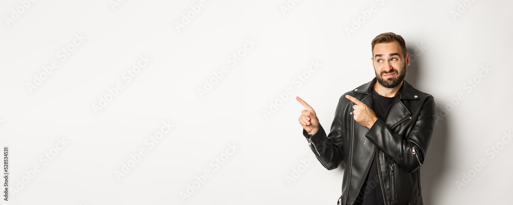 Skeptical and doubtful guy in black leather jacket, shrugging while ...