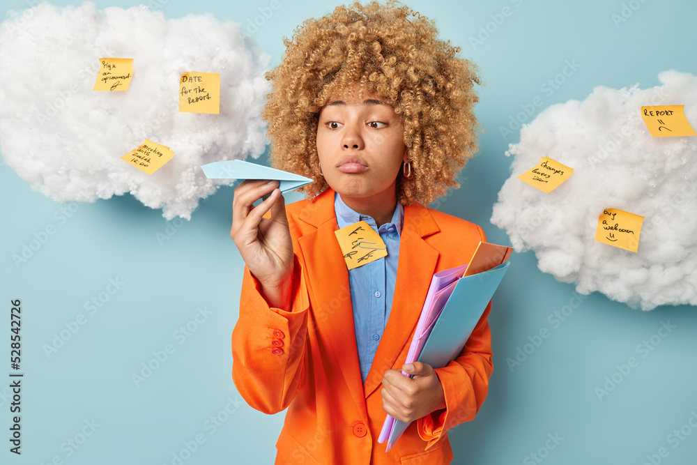 Sad businesswoman looks at paper plane has many tasks to do during ...