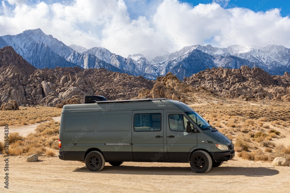 off road sprinter van in front of a snow covered mountain range in the ...