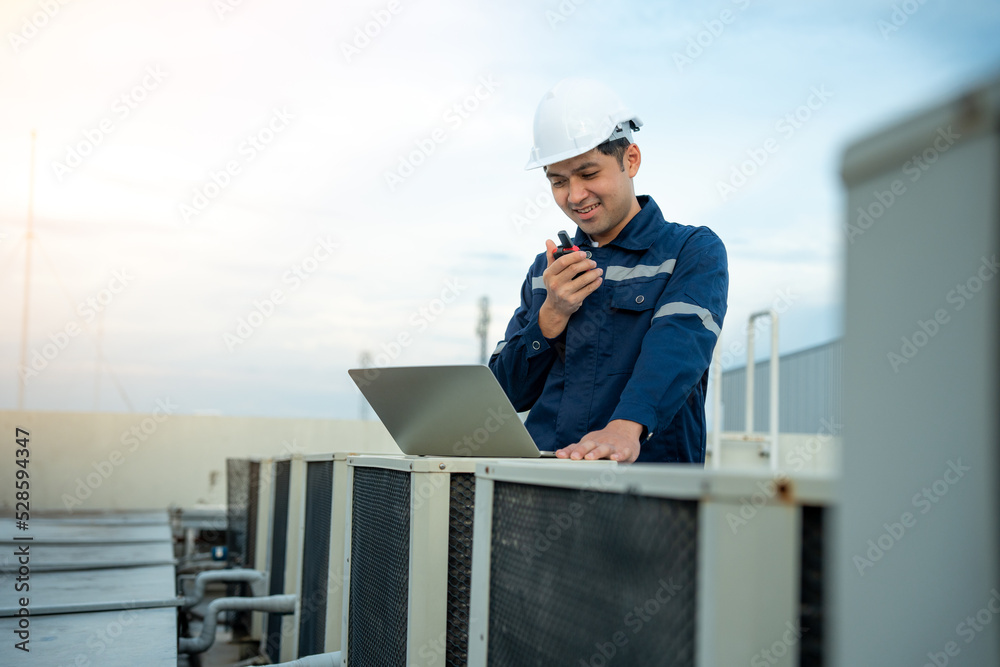Asian maintenance engineer wear helmet works on the roof of factory ...