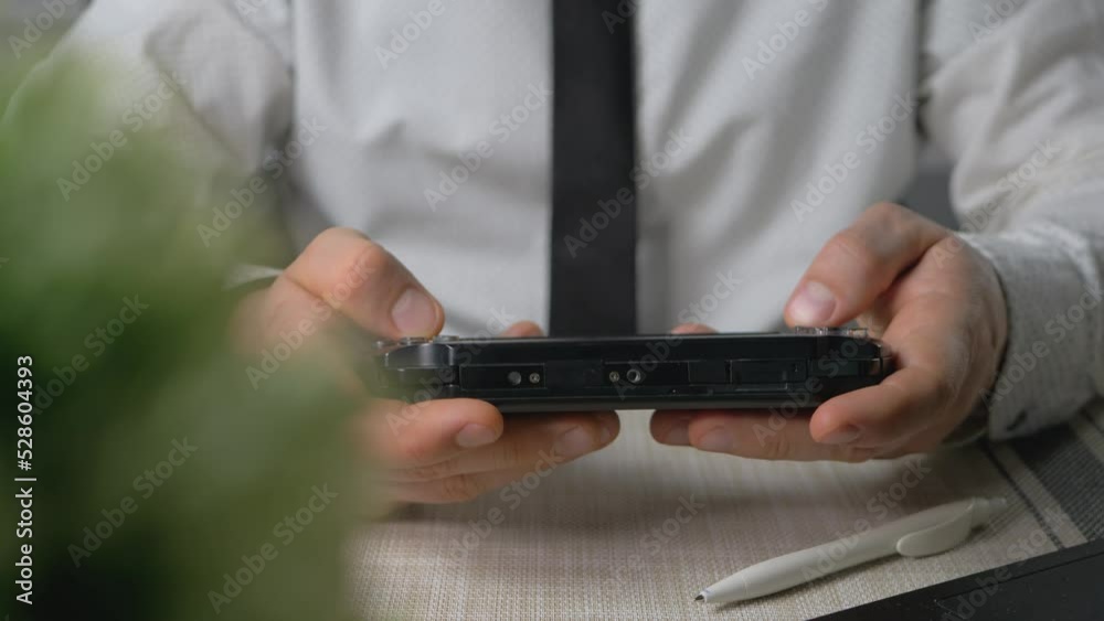 Video game handheld console in male's hands. Office man in white shirt ...