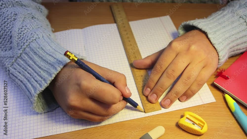 Close-up of a student's hands drawing a square with a pencil using a ...
