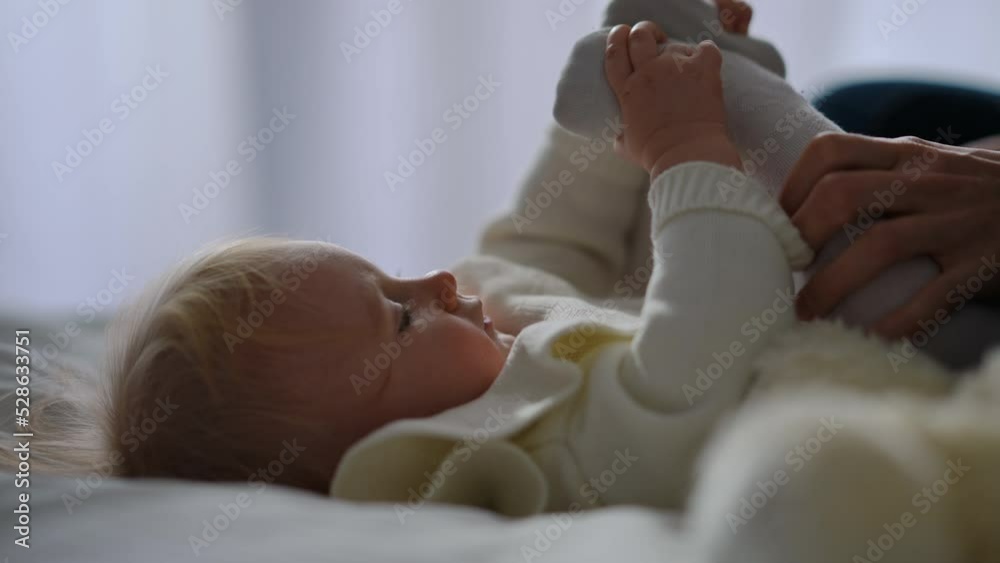 Vidéo Stock Side view relaxed baby girl playing with feet as female ...
