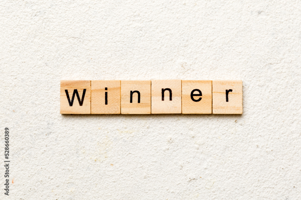 WINNER word written on wood block. WINNER text on cement table for your ...