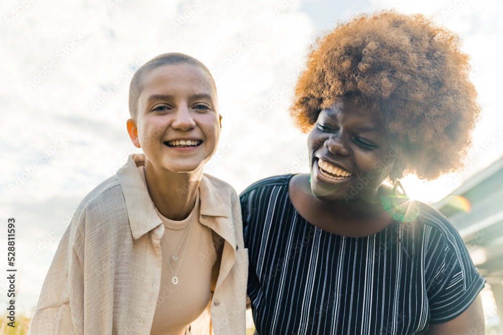 Close interracial friendship. Delighted happy mixed race girls smiling ...