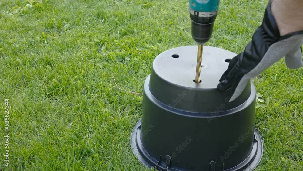 A man drilling the bottom of the pail using a drill in Estonia Stock ...