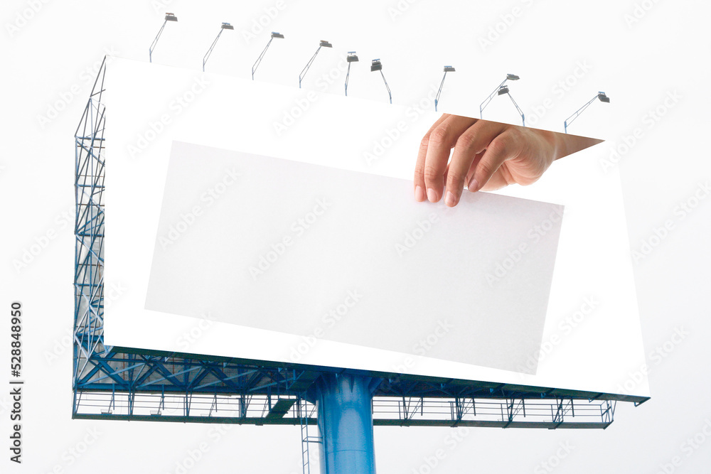 Advertising: Hand holding white empty paper on big billboard on ...