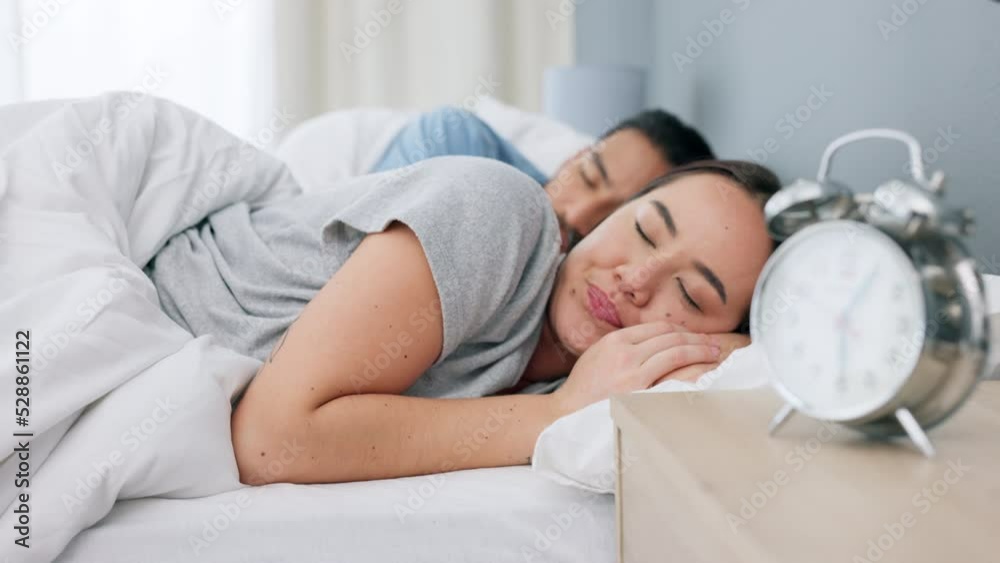 Alarm clock click, sleeping and couple in bed hit snooze to rest, relax ...