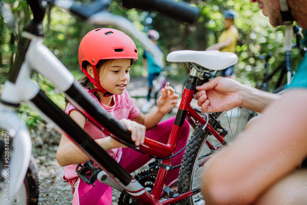 Young family with little children preapring for bike ride, standing ...