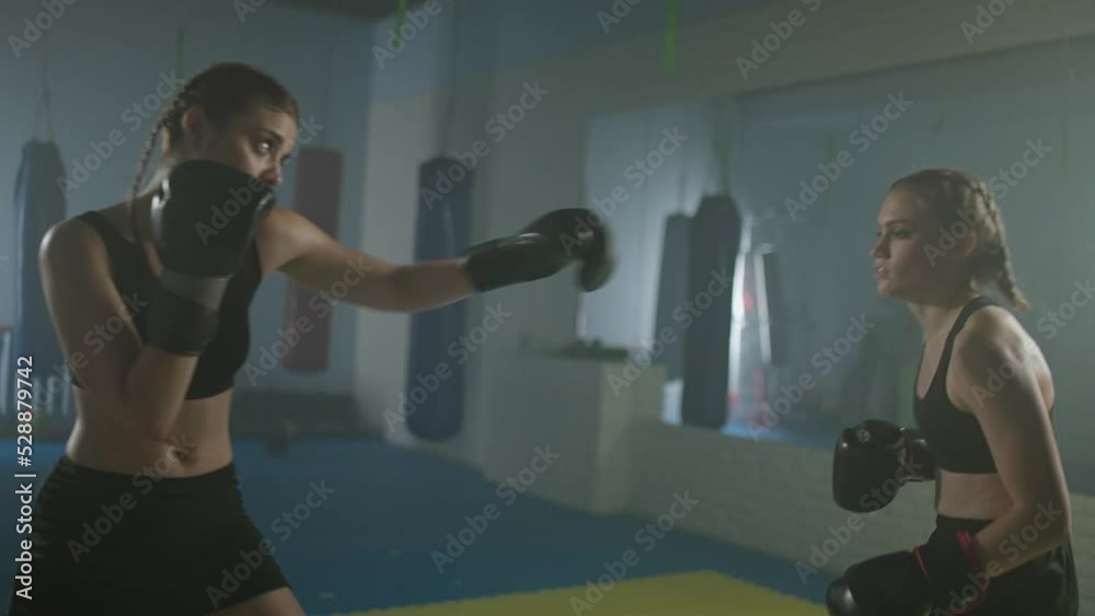 Sparring of two female fighters, training in the boxing gym, females ...
